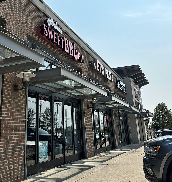 The bright red signage of Arkins Sweet BBQ Pit stands out like a beacon for hungry souls. Michigan's barbecue scene has a not-so-secret hero hiding in plain sight.