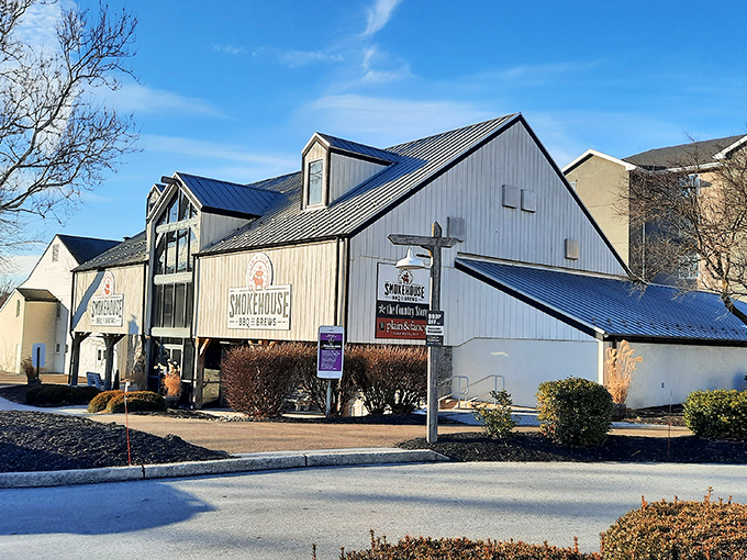 The barn-like exterior of Smokehouse BBQ & Brews stands proudly against a blue Pennsylvania sky, promising smoky delights within those timber walls.
