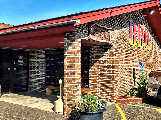 The brick facade of Big Guy's BBQ Roadhouse stands like a temple to smoked meat, its fiery BBQ sign a beacon to hungry travelers on Wisconsin highways.