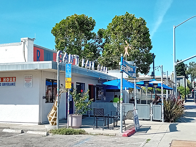 The neon-lit exterior of Rudy's Can't Fail Cafe stands as a beacon of comfort food in Emeryville, promising punk rock vibes and plates that satisfy.