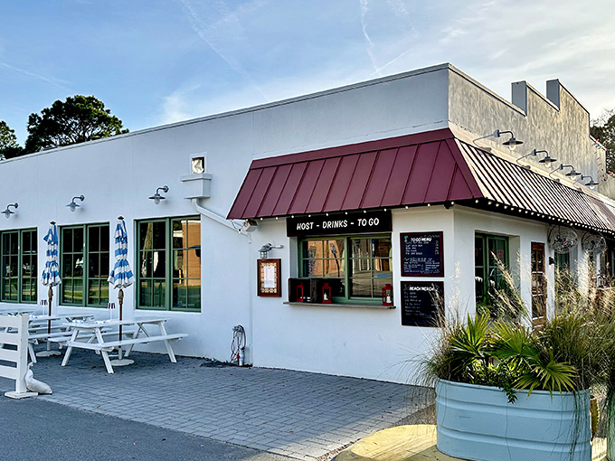 Sullivan's Fish Camp welcomes hungry seafood seekers with its cheerful white exterior, copper-colored roof, and those inviting blue umbrellas promising shade and satisfaction.