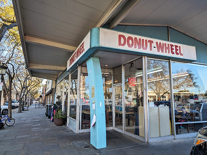 The iconic blue-trimmed facade of Donut Wheel stands like a beacon of sweetness on Livermore's First Street, promising delicious treasures within.