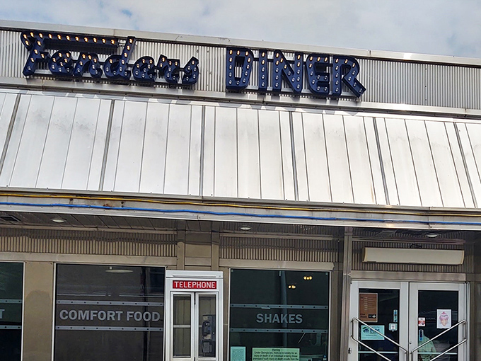 The iconic blue neon sign of Fenders Diner glows with promise, a beacon of comfort food that's been calling hungry travelers home for generations.