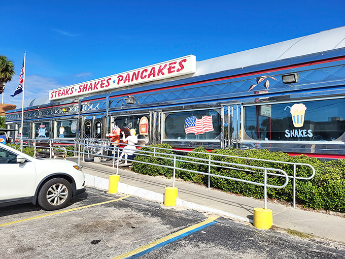 The gleaming silver exterior of All American Diner shines like a time capsule under the Florida sun, promising "STEAKS &bull; SHAKES &bull; PANCAKES" in bold red letters.