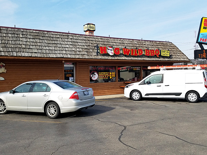 The log cabin exterior of Hog Wild BBQ stands like a beacon of smoky promise along Holland's roadside, calling to barbecue pilgrims far and wide.