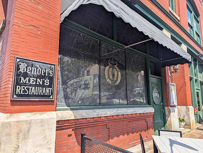 Bender's Tavern's charming brick exterior welcomes you with American flags and an inviting patio—history and hospitality standing proudly in downtown Canton.