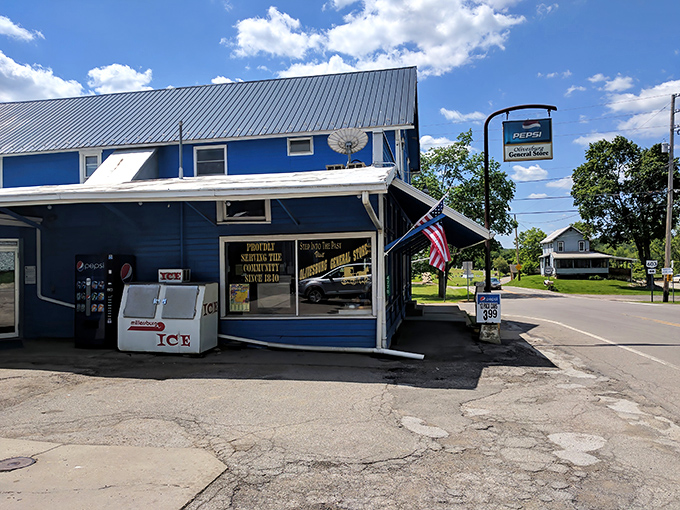 The blue clapboard exterior of Olivesburg General Store stands like a culinary lighthouse at a rural crossroads, beckoning hungry travelers with promises of sandwich perfection.