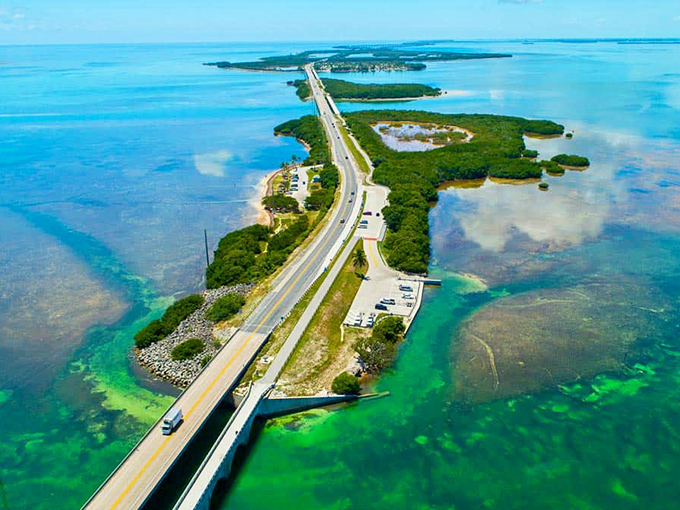 The ultimate road trip fantasy: a ribbon of asphalt suspended between impossible shades of blue, connecting emerald islands like a necklace of tropical pearls.