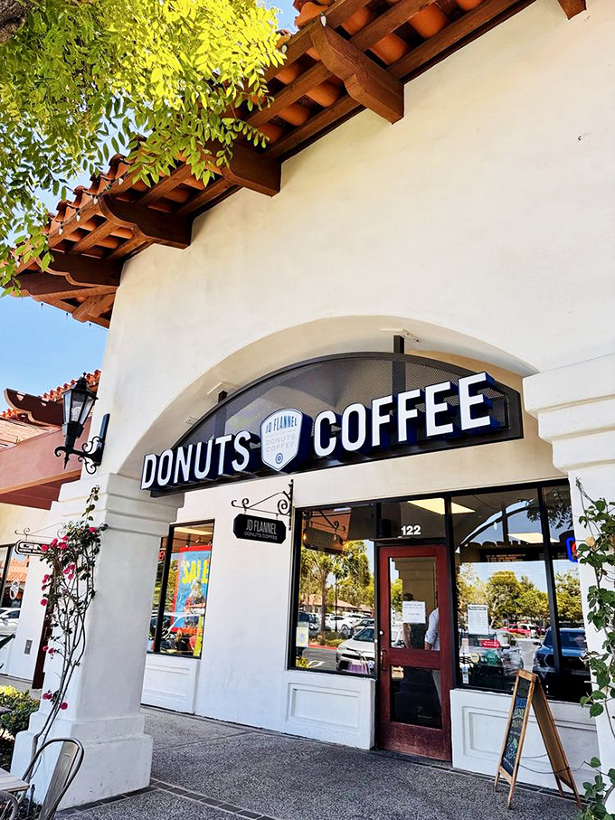 Mission-style charm meets donut paradise at JD Flannel's entrance, where bougainvillea frames the doorway like nature's own welcome committee.