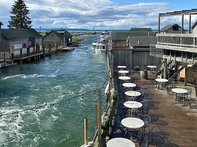 The waterfront deck at The Cove offers front-row seats to Leland's historic Fishtown, where weathered shanties and bobbing boats create Michigan's most charming dining backdrop.