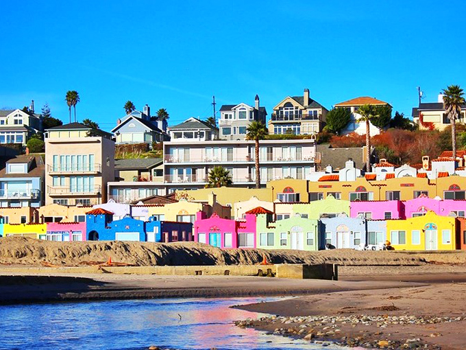The famous rainbow-colored Venetian Court cottages create a perfect mirror image on Soquel Creek at sunset. California coastal magic at its finest.