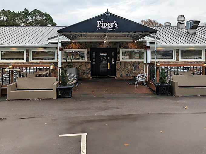The stone facade and distinctive sign of The Piper's Tavern stands like a culinary fortress, promising British comfort in the heart of North Carolina.