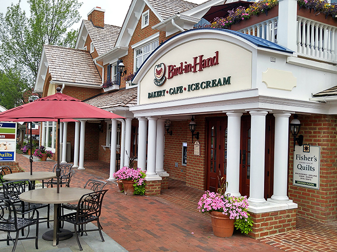 The stately brick exterior of Bird-in-Hand Bakery & Cafe stands like a temple to carbs, promising sweet salvation within those white columns.