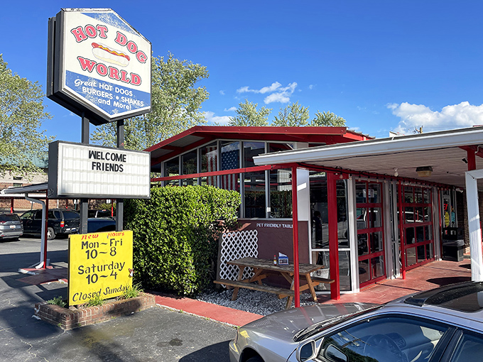 The iconic Hot Dog World sign beckons hungry travelers like a neon-lit lighthouse for comfort food enthusiasts. "WELCOME FRIENDS" indeed!