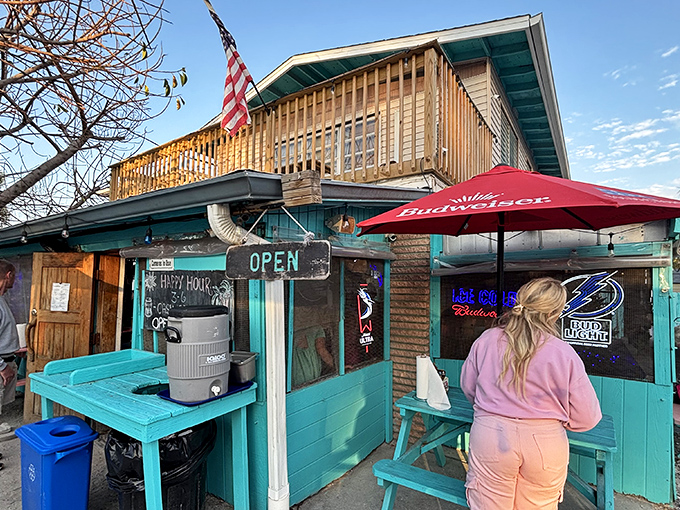 The turquoise-painted shack with wooden deck screams "Florida beach burger joint" louder than a seagull eyeing your fries. Old-school charm personified.