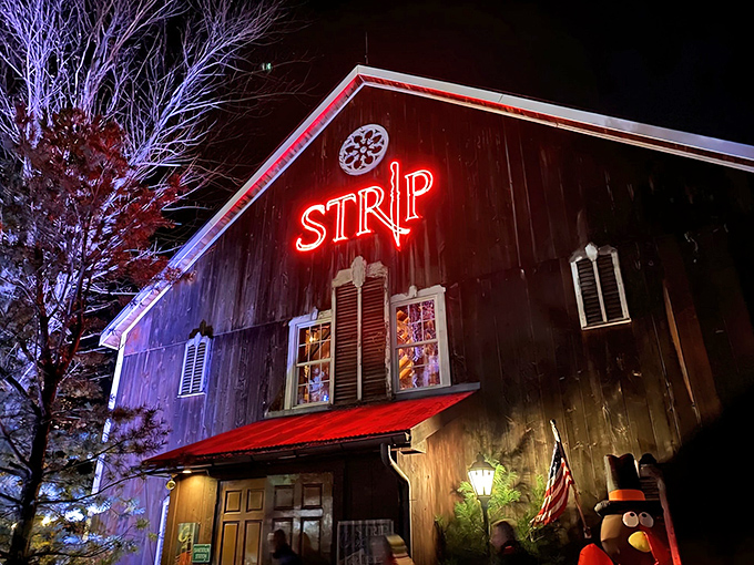 Not your average barn raising! Strip Steakhouse's weathered exterior and glowing red sign promise rustic charm with a carnivorous twist.