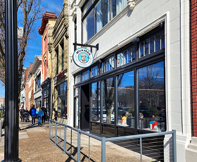 The iconic blue Milkman sign beckons like a lighthouse for the hungry, promising juicy burgers and creamy shakes in Cincinnati's urban landscape.