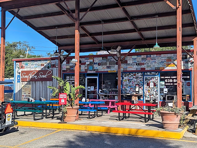 The barbecue promised land awaits behind this weathered wood facade, where license plates from pilgrims past create a roadmap to smoky perfection.