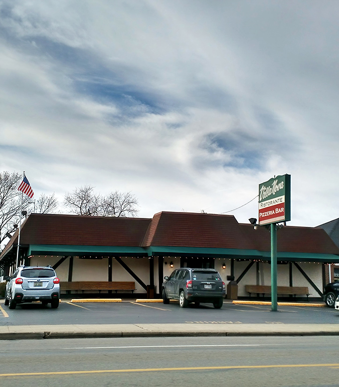 Villa Nova's charming Tudor-style exterior stands like a culinary time capsule, promising Italian delights behind its unassuming fa&ccedil;ade. The American flag waves a patriotic welcome.