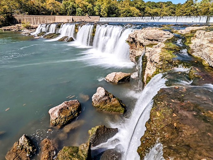 Nature's perfect horseshoe design spills over ancient chert ledges, creating Missouri's largest continuously flowing waterfall—a geological masterpiece hiding in plain sight.
