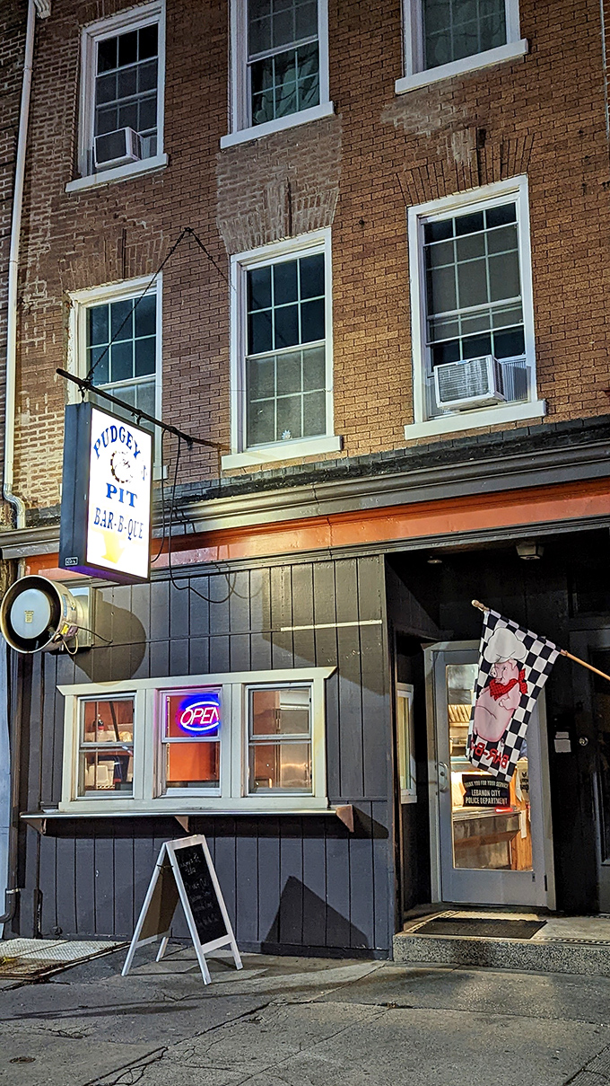 The unassuming storefront of Pudgey's Pit hides barbecue greatness like a superhero's secret identity. That neon "OPEN" sign might as well say "PARADISE."
