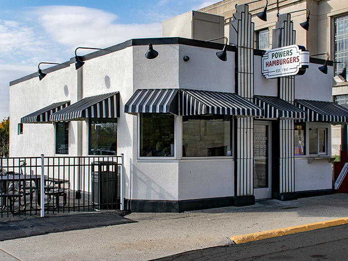 The unassuming white building with its jaunty black-and-white striped awnings stands like a time capsule of American burger history in downtown Fort Wayne.
