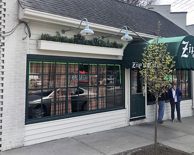 The charming exterior of Zip's Cafe welcomes you with colorful flower boxes and that iconic green awning&mdash;a Cincinnati landmark that promises comfort without pretension.