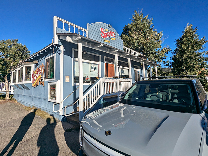 The blue cottage with the red sign isn't trying to be Instagram-famous—it's too busy being delicious. Mountain breakfast paradise found.
