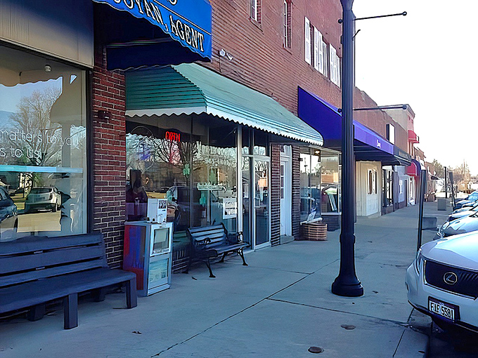 The unassuming storefront of Yum-Ee Donuts, complete with weathered bench, is like finding a treasure map where X marks the spot for deliciousness.