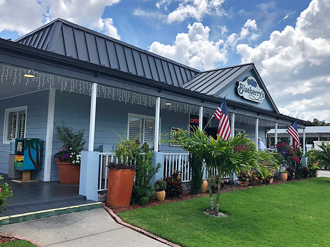 The classic white exterior with American flags and tropical landscaping says "come on in" before you've even parked your car.