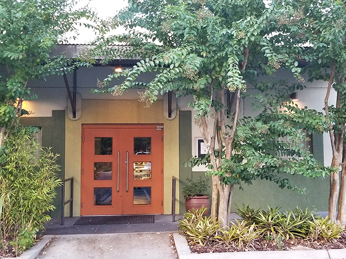 The unassuming exterior of Mildred's Big City Food, where leafy trees provide shade and a hint of the natural ingredients awaiting inside.