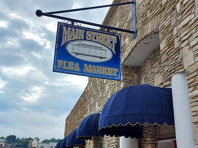 The iconic blue and gold sign welcomes treasure hunters to Main Street Flea Market, where Branson's hidden gems await behind that stone facade.