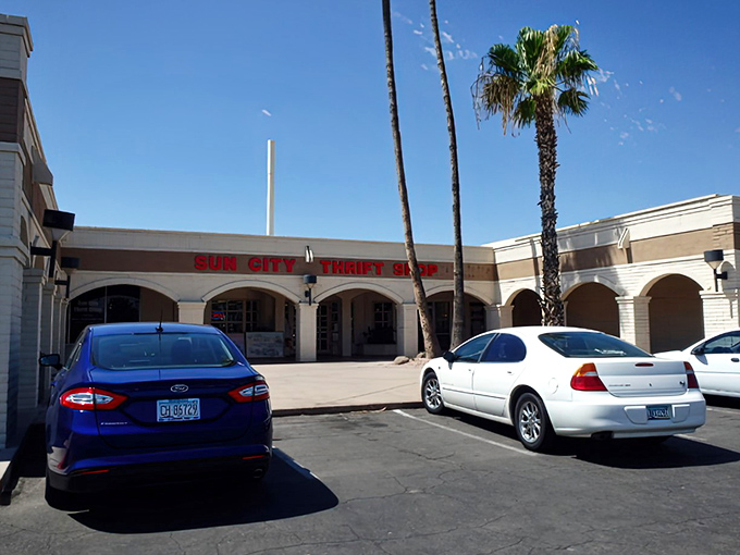 The iconic Sun City Thrift Shop facade welcomes treasure hunters with its distinctive Spanish-style architecture and desert palm trees.