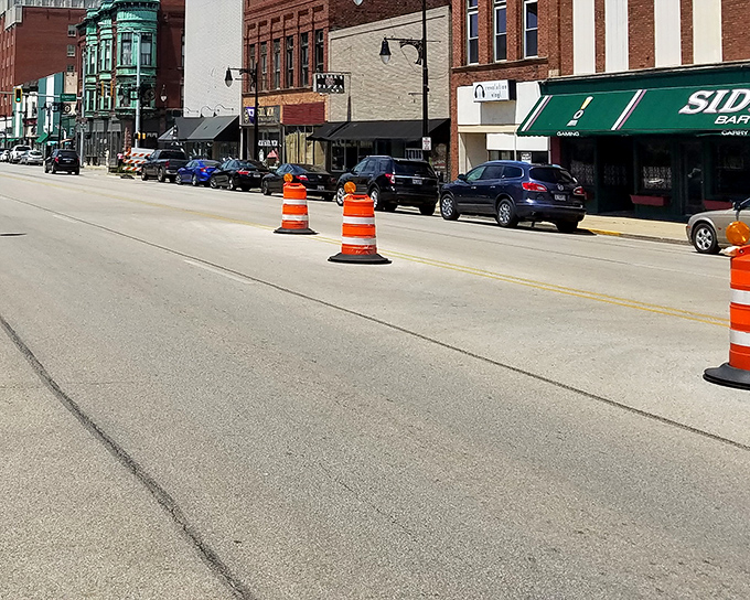 Downtown Galesburg's historic brick facades stand like sentinels of Midwestern prosperity, where orange construction cones are the only thing slowing down the relaxed pace of life.