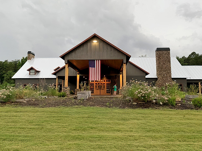 The rustic lodge exterior of Saskatoon welcomes hungry travelers with its dramatic peaked roof and American flag. Wilderness dining awaits beyond those wooden doors.