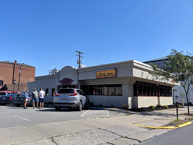 The unassuming white exterior of The Waffle Shop beckons with its simple orange waffle logo&mdash;proof that the best breakfast spots don't need flashy facades to deliver morning magic.