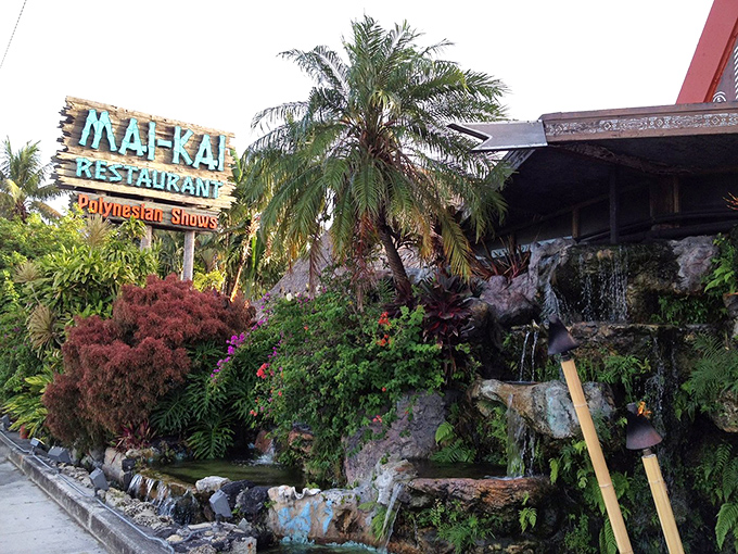 The iconic Mai-Kai sign stands like a neon-lit portal to Polynesia, promising tropical adventures amid lush gardens and cascading waterfalls.