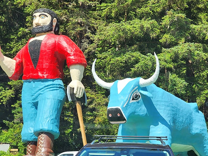 The ultimate odd couple of American folklore: Paul Bunyan waves hello while Babe the Blue Ox stands stoically beside him, surrounded by towering redwoods.