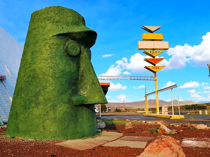 The stoic green guardian of Route 66 stands watch, its expression unchanging yet somehow judging your life choices with silent Tiki wisdom.