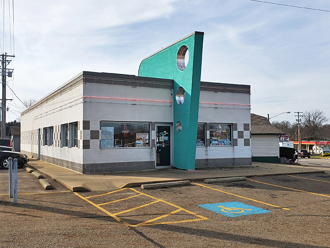The teal facade of Doug's Classic '57 Diner stands like a time machine in Alliance, beckoning hungry travelers with its distinctive porthole windows and checkerboard trim.