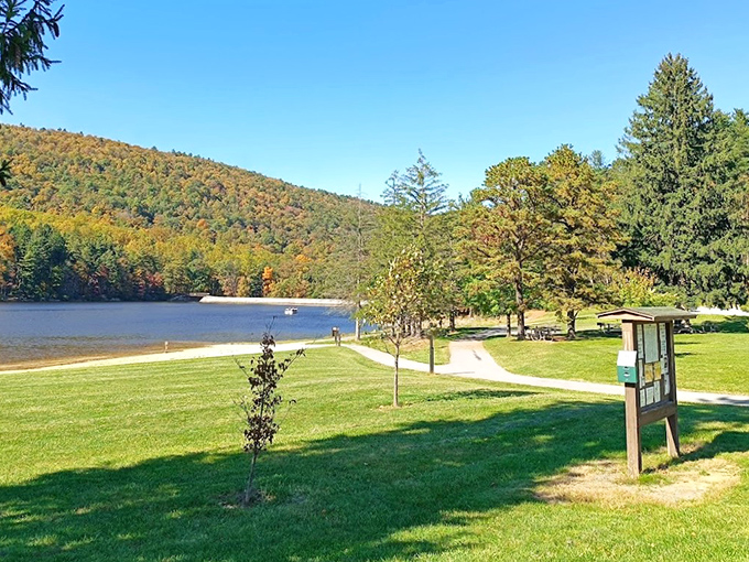 Mother Nature's masterpiece on full display &ndash; autumn mountains embracing a serene lake while picnic tables patiently wait for your sandwich collection. 