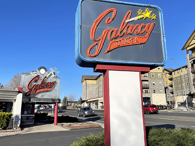 That iconic neon sign beckons like a beacon of breakfast hope on Route 66. The cosmic promise of comfort food awaits beneath those glowing letters.