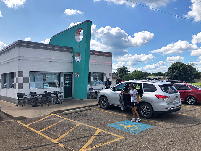 The teal facade of Doug's Classic '57 Diner stands like a time machine in Alliance, beckoning hungry travelers with its distinctive porthole windows and checkerboard trim.