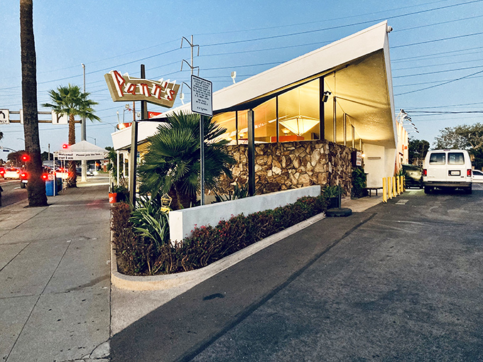 The unmistakable angular roof and neon sign of Pann's stands as a mid-century modern beacon, promising comfort food and nostalgia in equal measure.