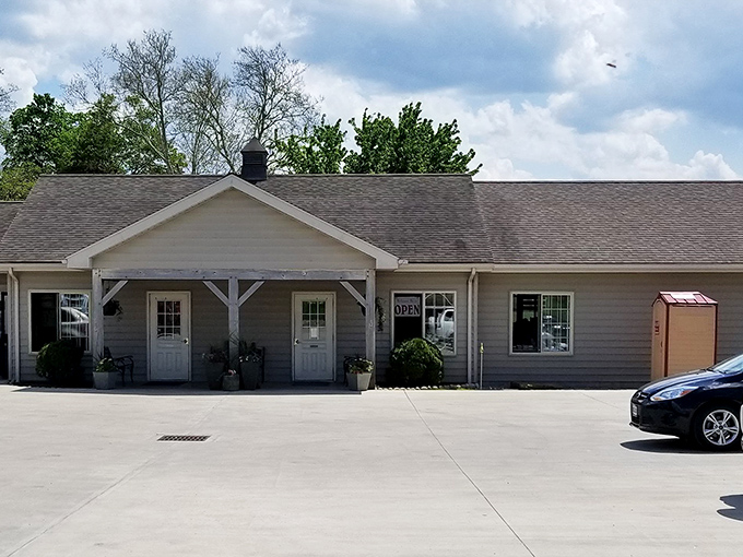 The unassuming exterior of Country Crust Bakery, where lush greenery and simple outdoor seating hint at the carb-laden treasures waiting inside.