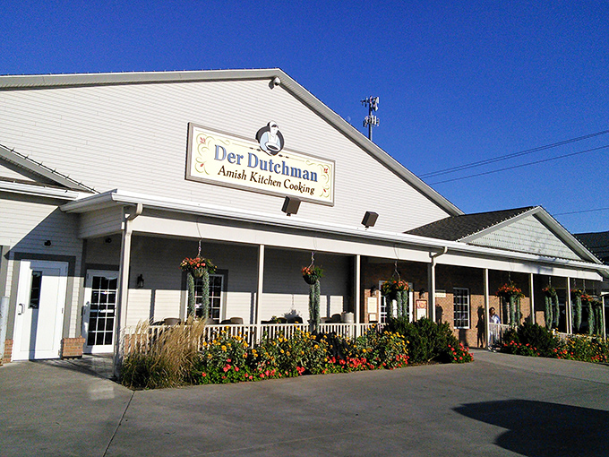 The white clapboard exterior of Der Dutchman welcomes visitors with hanging flower baskets and a front porch that practically whispers "come hungry, leave happy."