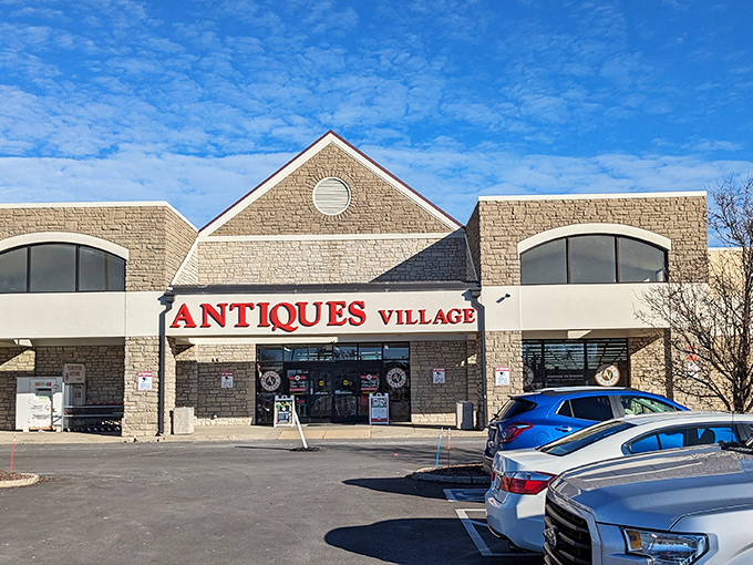 The stone facade of Antiques Village stands like a temple to nostalgia, its bold red sign a beacon to treasure hunters across Ohio.