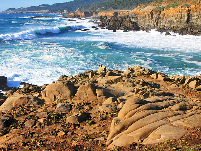 Nature's perfect drama unfolds where rugged sandstone meets the relentless Pacific, creating a coastline that belongs on the cover of every California tourism brochure.