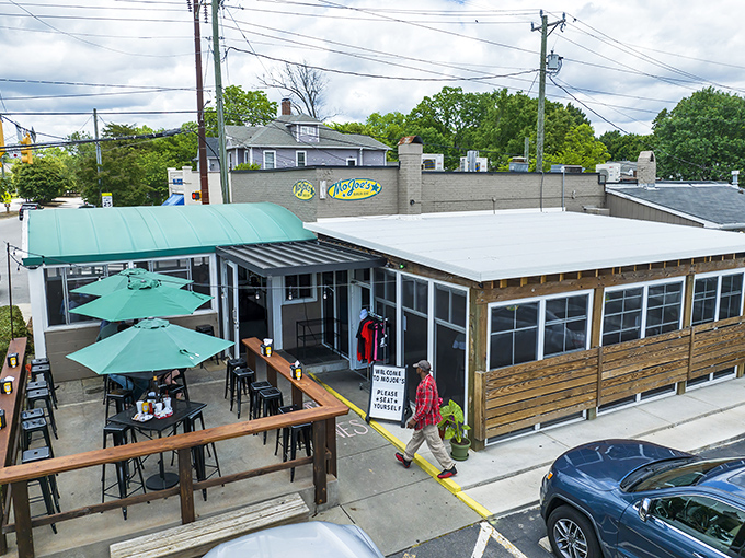 MoJoe's exterior beckons with its inviting green awnings and wooden patio. The perfect spot for burger enthusiasts to begin their culinary adventure.