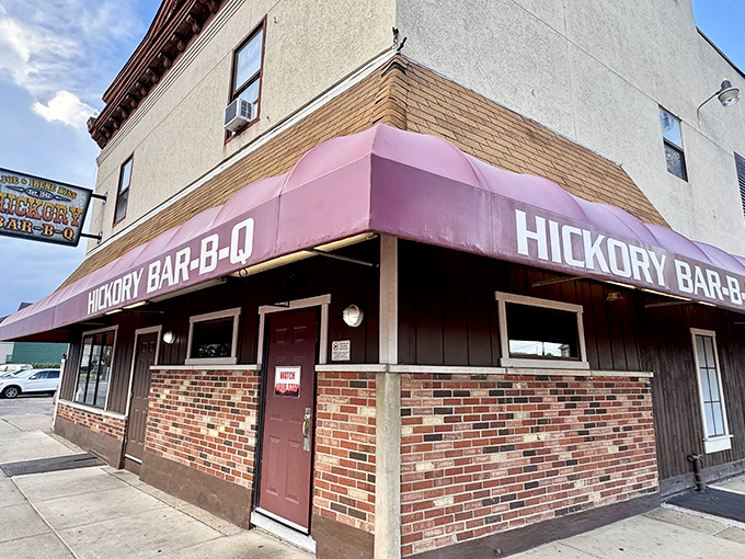The iconic burgundy awning of Hickory Bar-B-Q stands as a beacon of smoky promise on this Dayton corner. Barbecue salvation awaits inside.